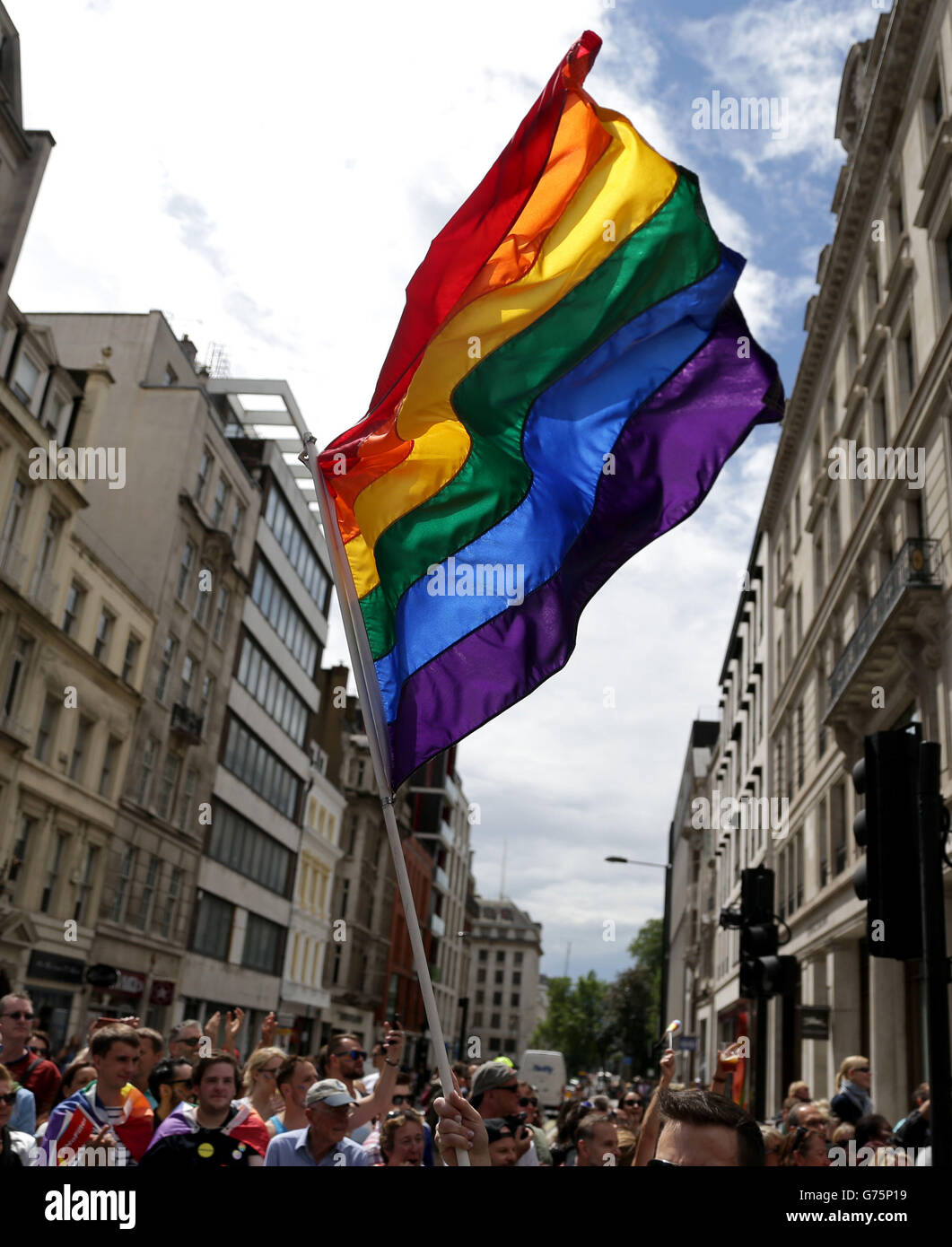 A rainbow flag is held aloft as the Pride in London parade makes its ...