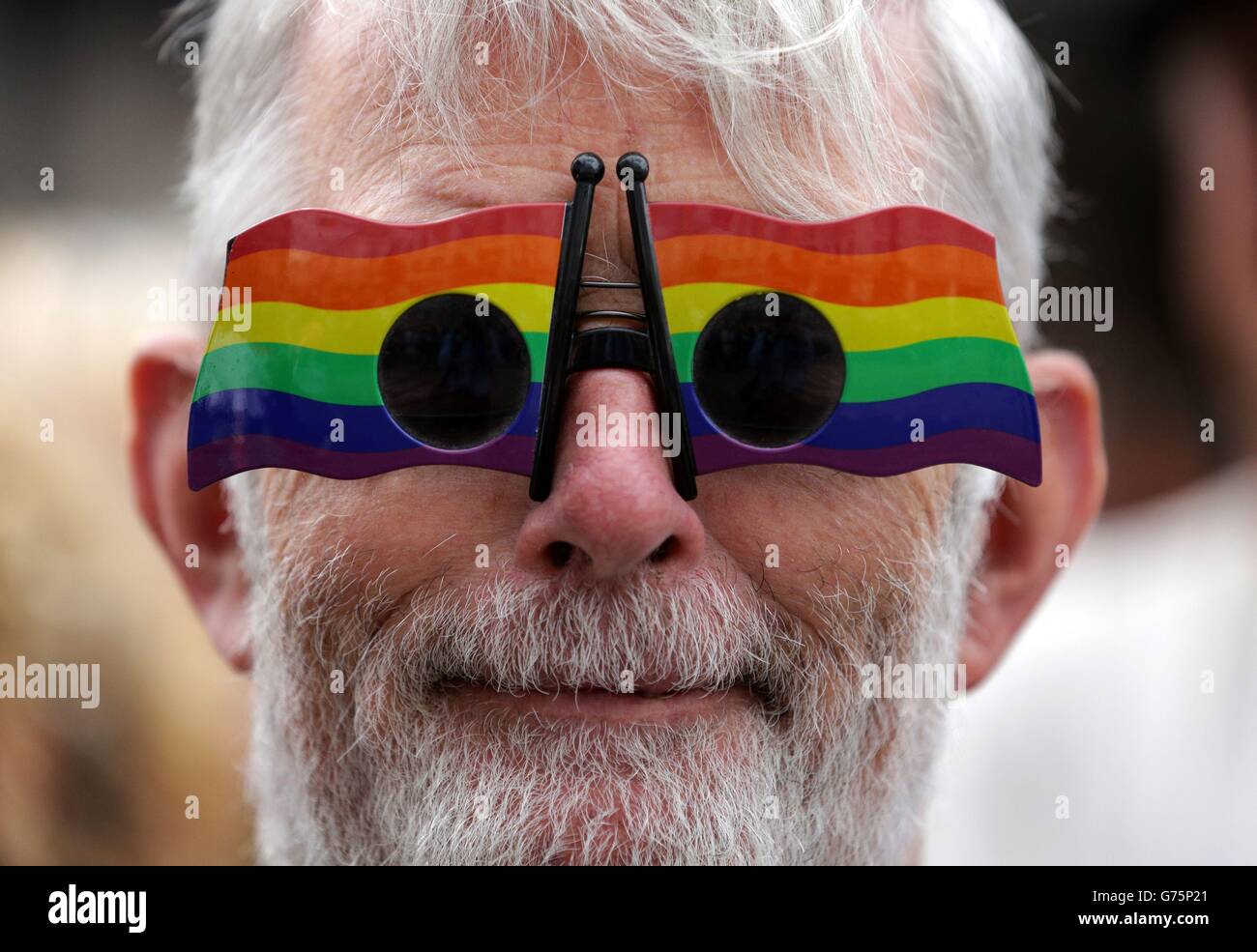 A man wearing rainbow glasses attending the Pride in London parade, as ...