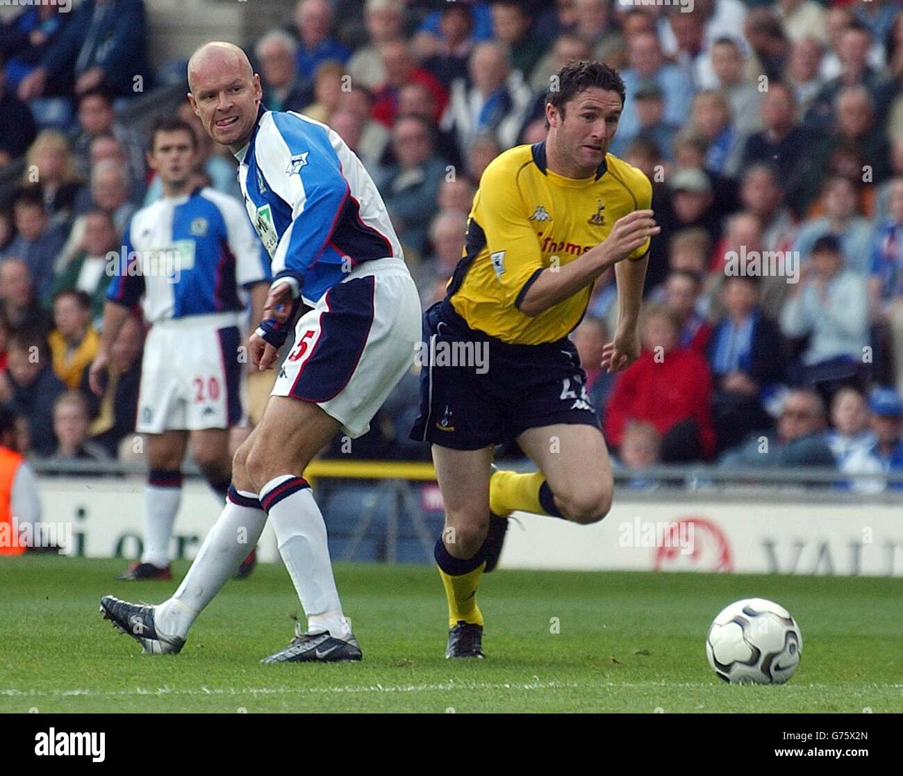 Robbie Keane of Tottenham Hotspur (r) turns past Henning Berg of ...