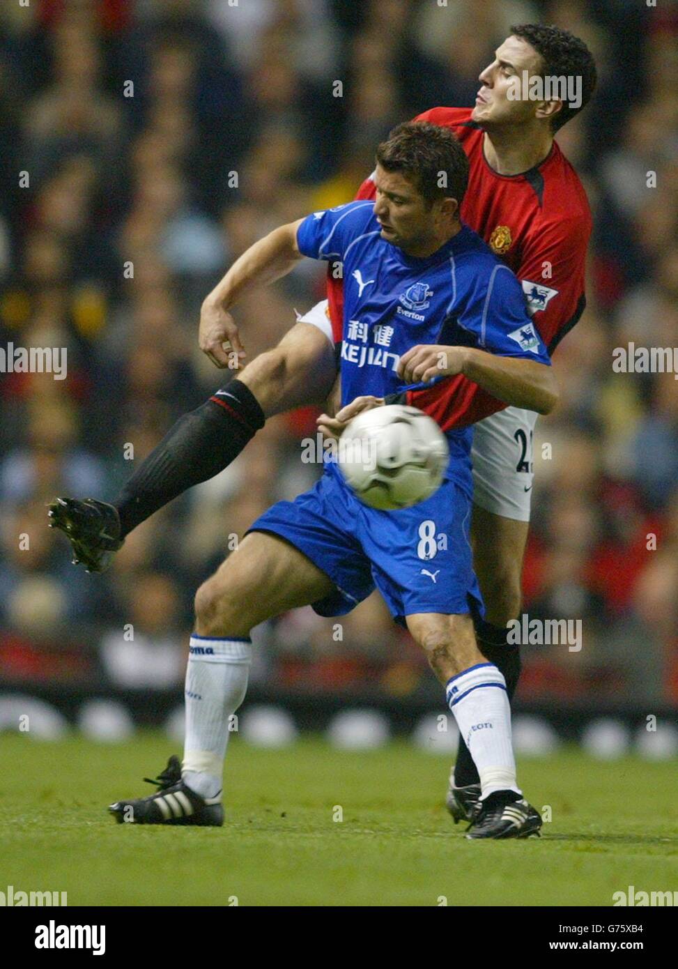 Manchester United's John O'Shea challenges Tomasz Radzinski of Everton ...