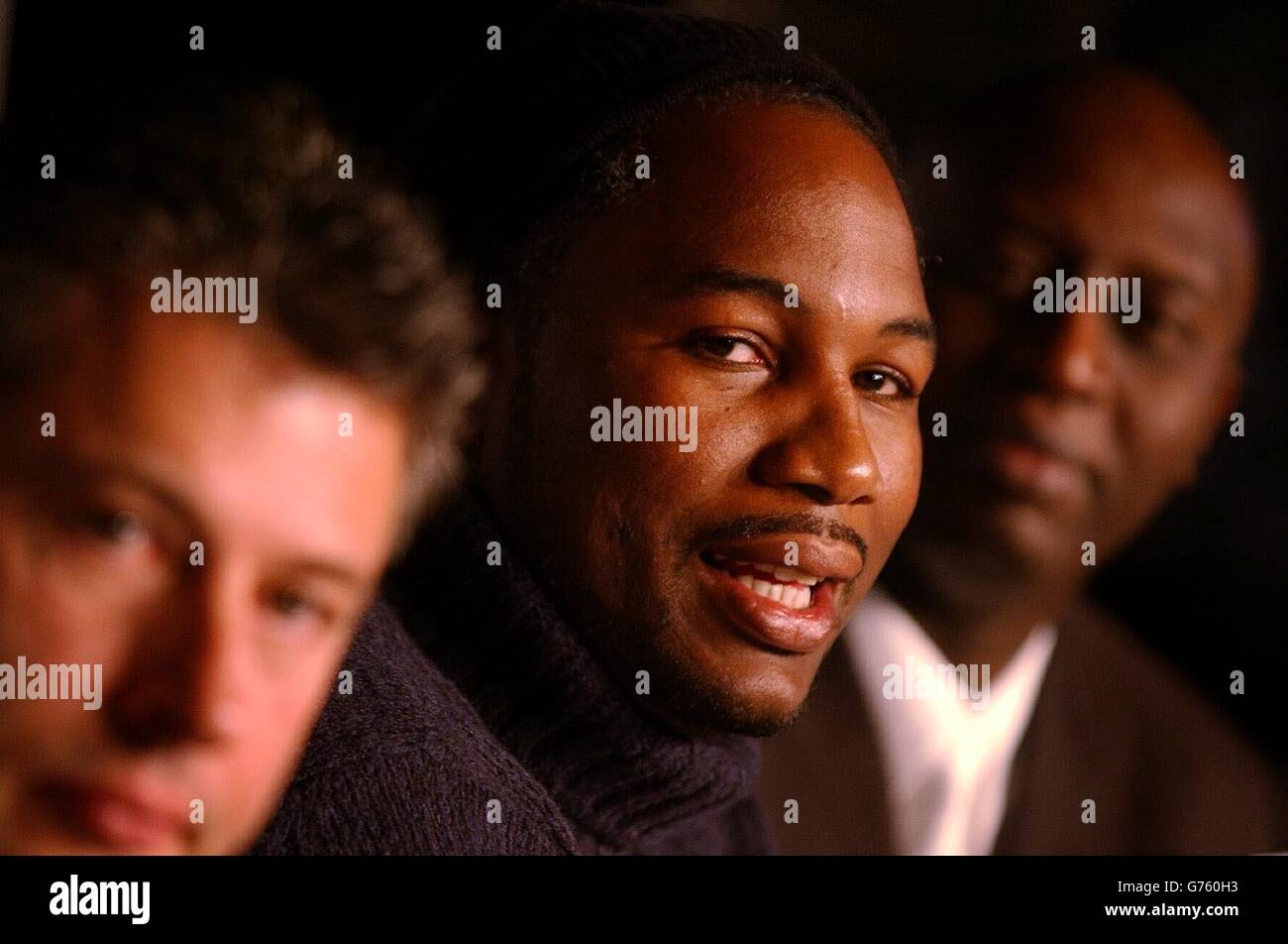 Lennox Lewis, with manager, Adrian Ogun, in background , and promoter, Jerome Anderson ...