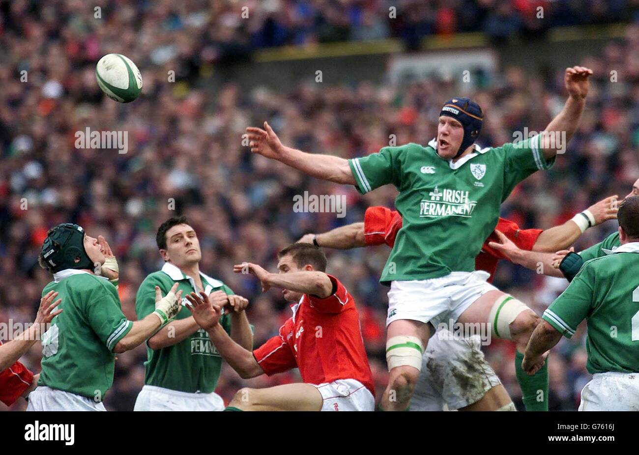 Ireland's new cap Paul O'Connell (right), tips the ball to team mate ...