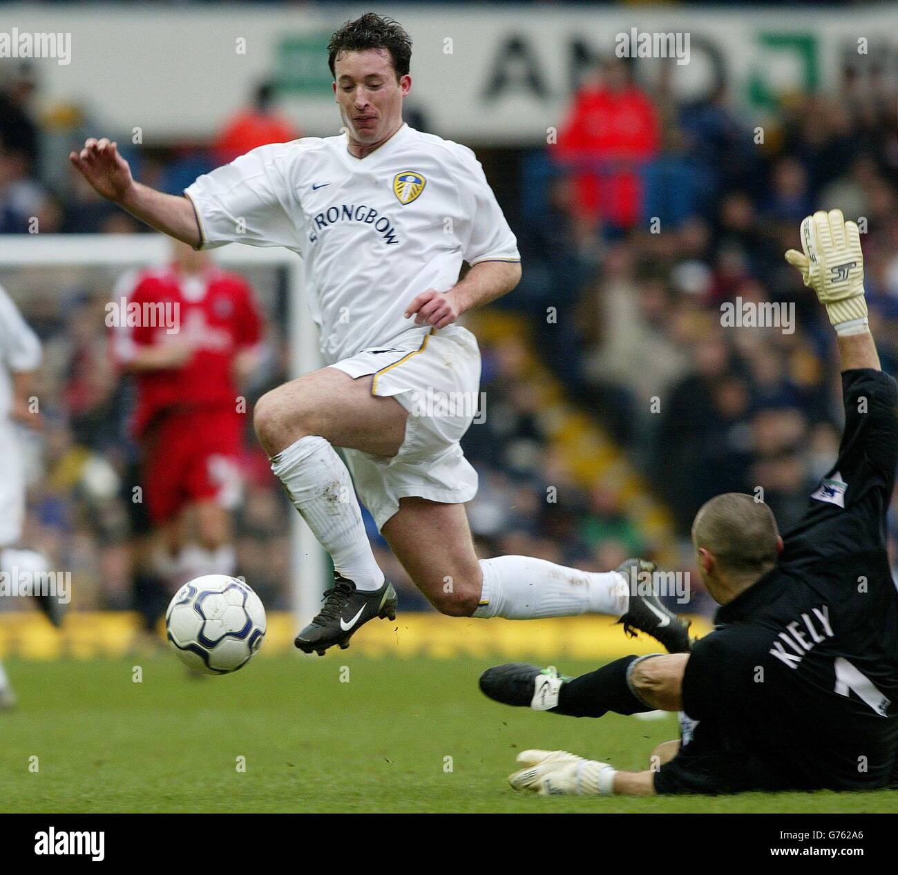 Leeds United's Robbie Fowler skips over a challenge by Charlton ...