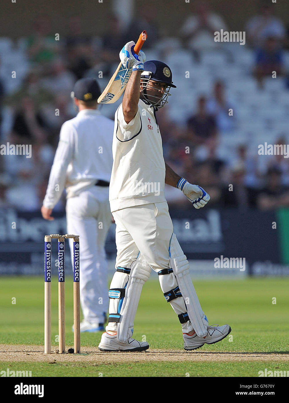 India's MS Dhoni raises his bat after reaching a half century against ...