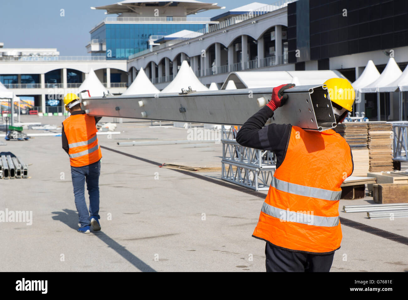 workers carry construction metal pipes Stock Photo - Alamy