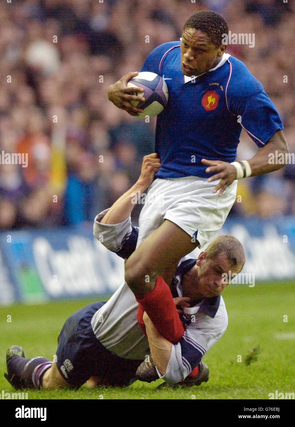 France's Jimmy Marlu is brought down by Scotland's Chris Paterson ...