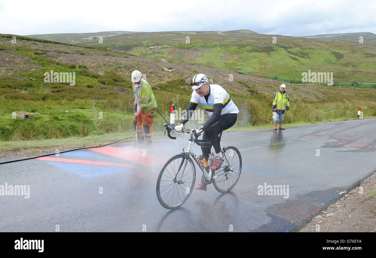 Workmen clean a Union flag off the road near Reeth on Stage one as ...