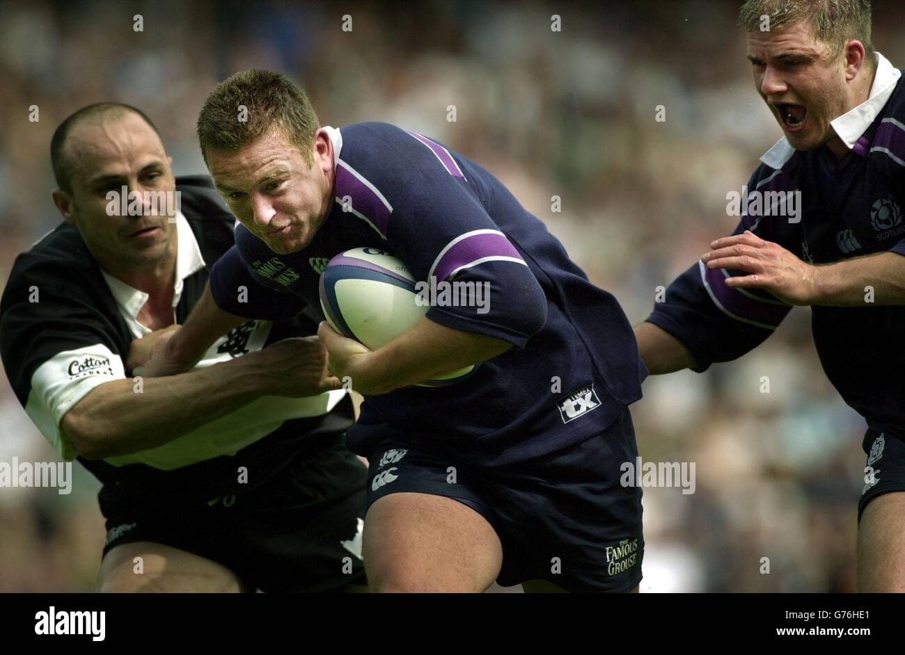 Scotland's Brendan Laney holds off Barbarian Peter Muller, watched by ...