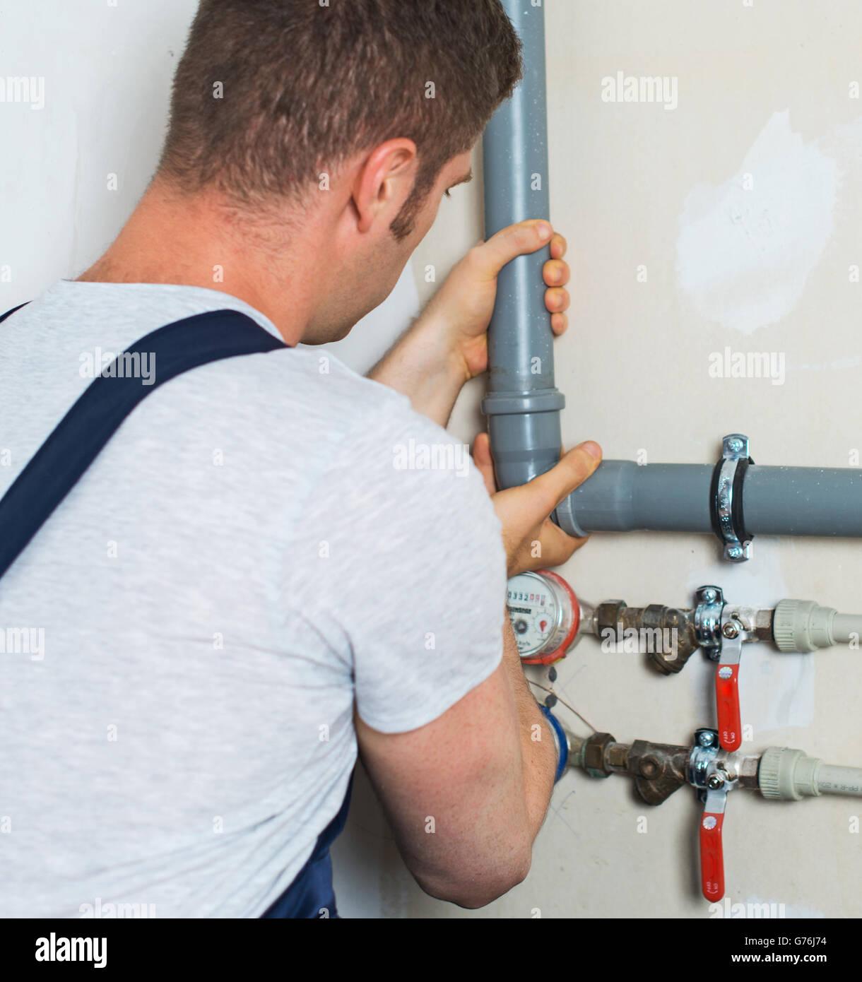 Male plumber assembling water pipes Stock Photo - Alamy