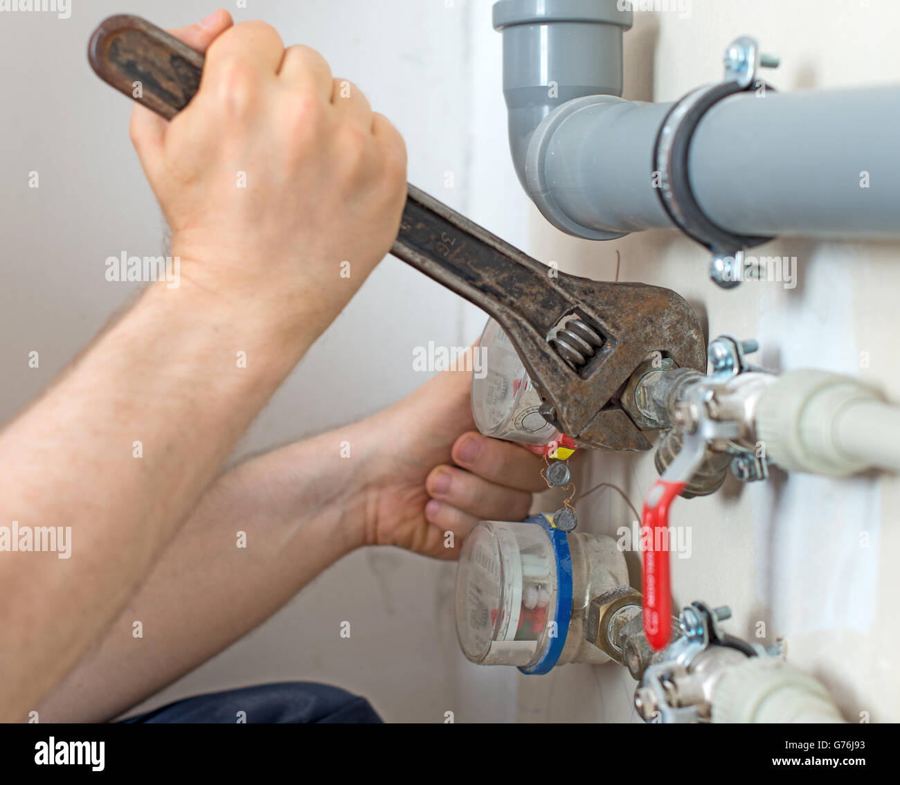 Male plumber fixing water meter with adjustable wrench Stock Photo - Alamy