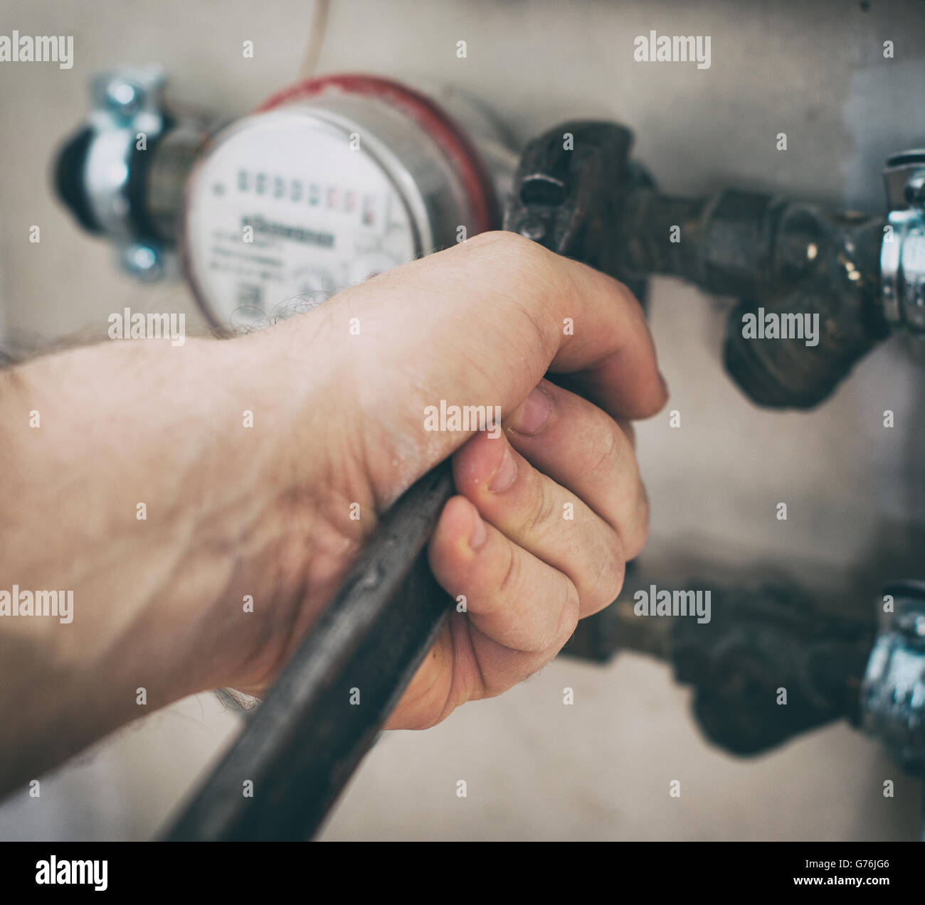 Male plumber fixing water meter with adjustable wrench Stock Photo - Alamy