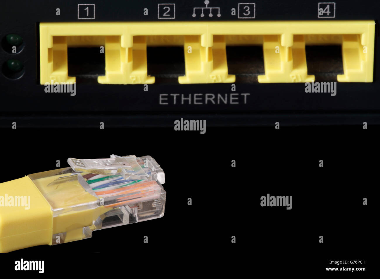 foreground of a yellow network cable and four network ports at the ...