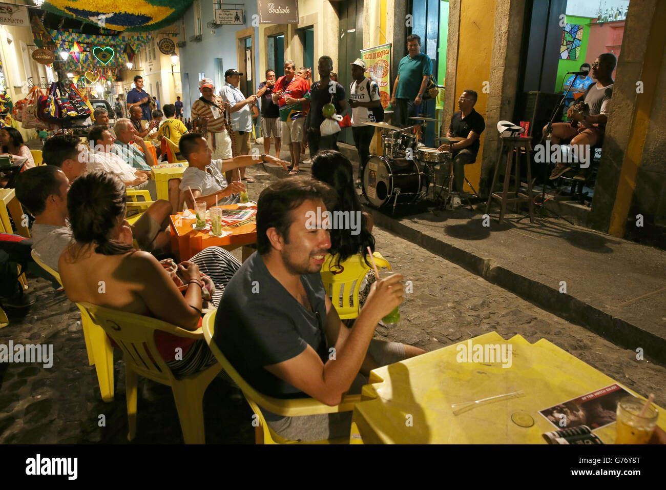 Two piece band play music from a bar on the streets to a watching crowd ...