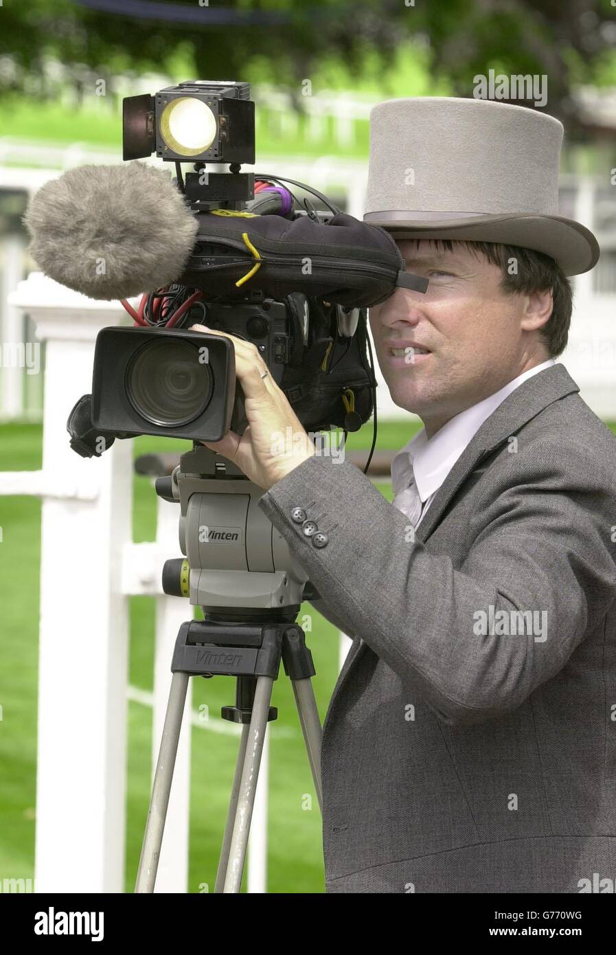 A BBC TV cameraman wears top hat and tails, in the paddock area at ...