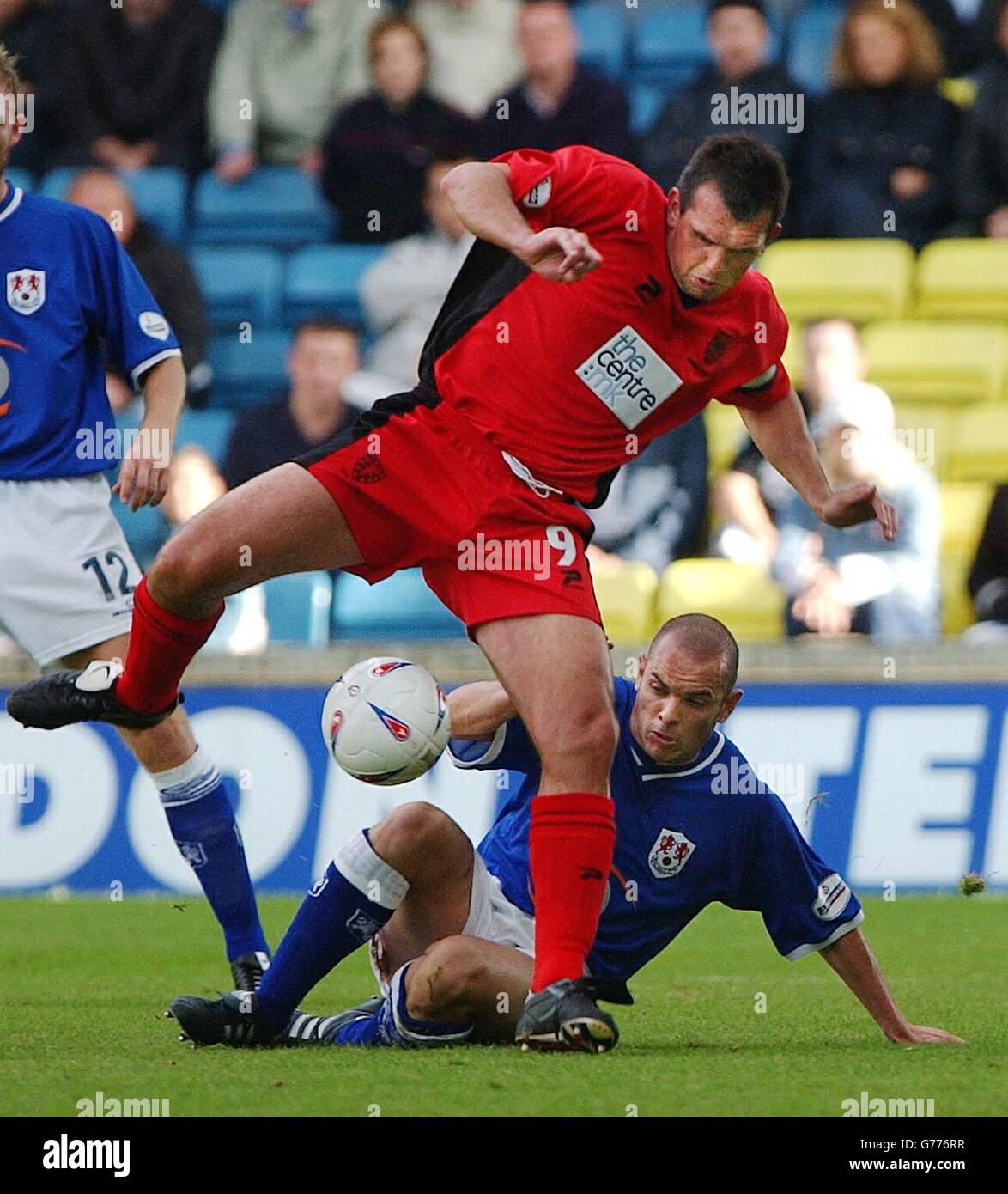 Robbie Ryan, in blue, of Millwall, gets a tackle in on Neil Shipperley ...