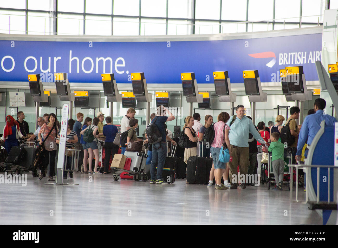 Passengers queues to drop their bags off as they check-in for their ...