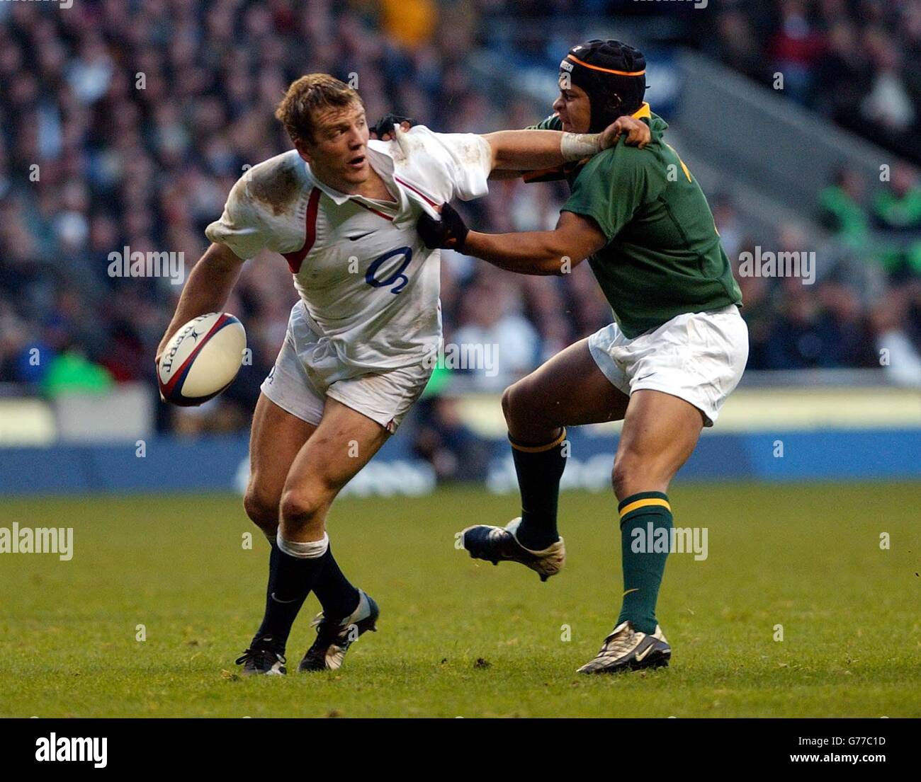 England's Mike Tindall (left) is caught by South Africa's Adrian Jacobs ...