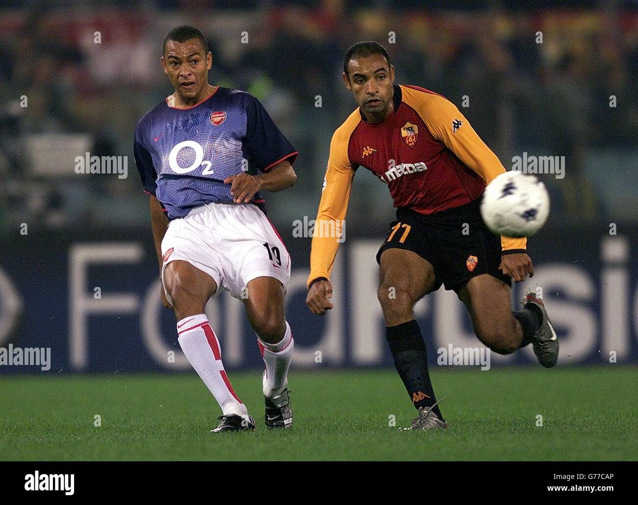 Gilberto (left) gets his pass away under pressure from Arsenal's ...