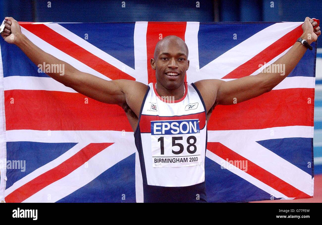 Great Britain's Marlon Devonish holds up the British flag after winning ...