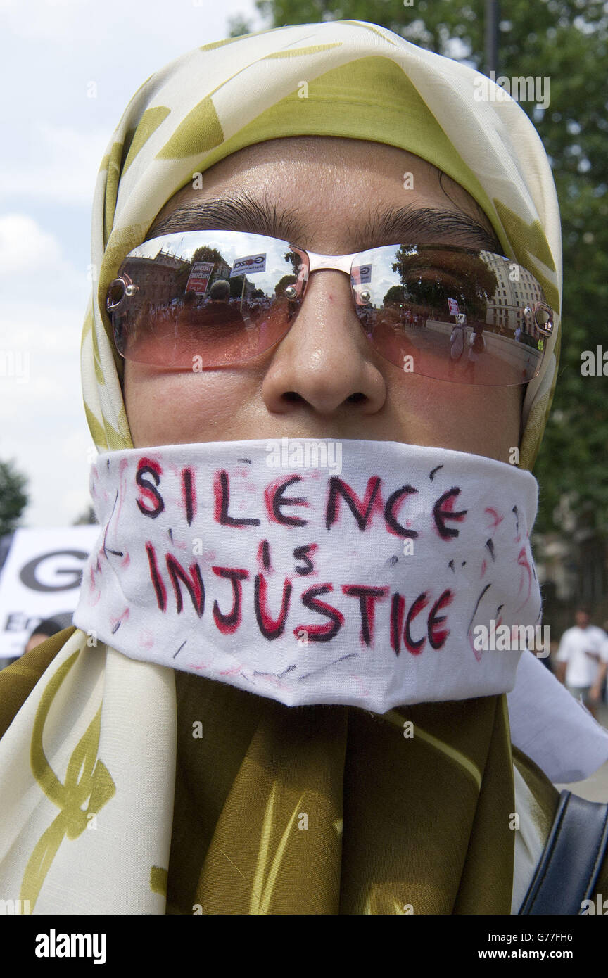 A female protester against military action in Gaza wears a 'Silence is ...