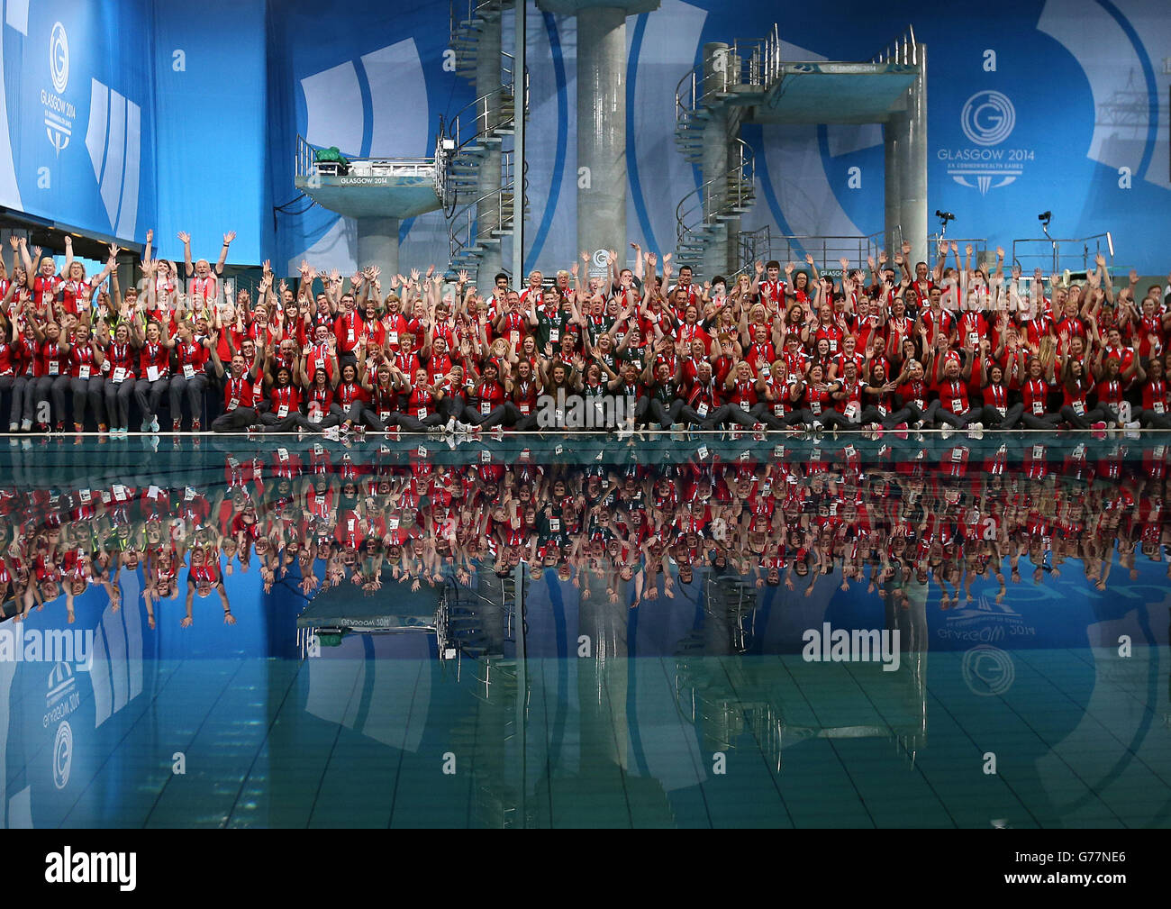 Volunteers are reflected in the pool as they pose for a group picture ...