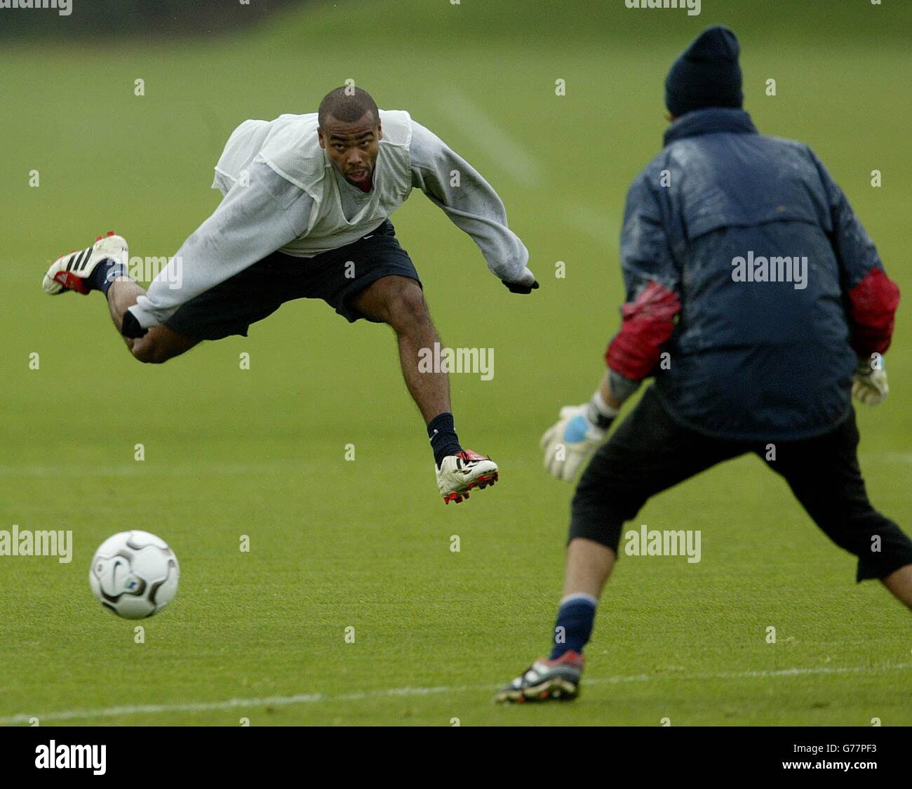 Arsenal's Ashley Cole (left) crosses the ball in front of keeper Stuart ...