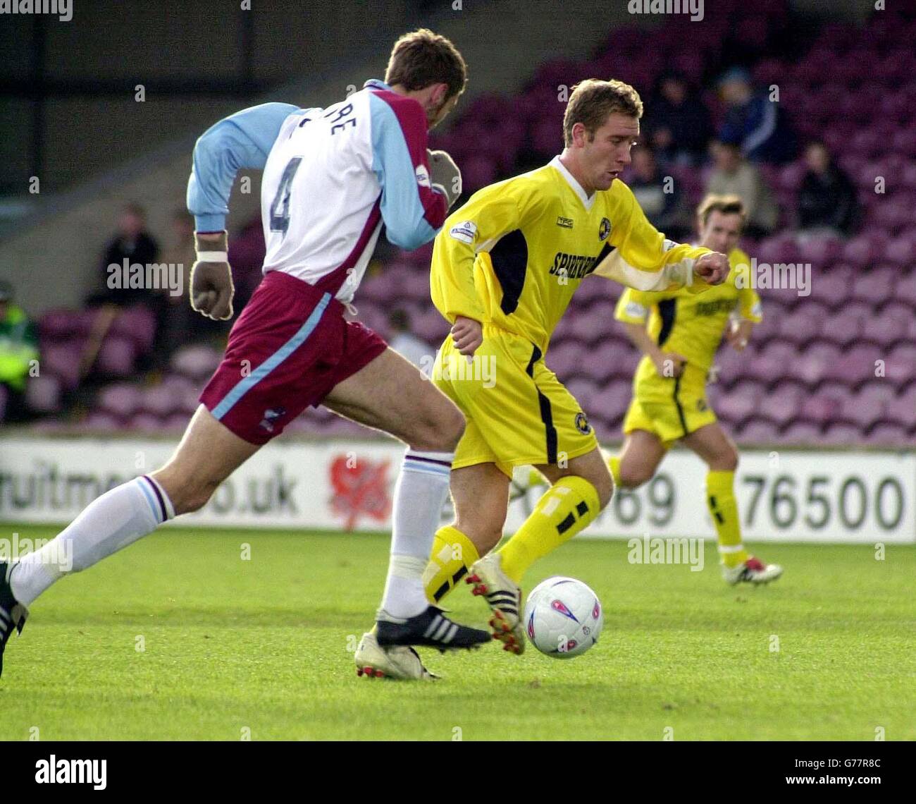 Scunthorpe's Jamie McCombe (left) battles with Torquay's David Graham ...