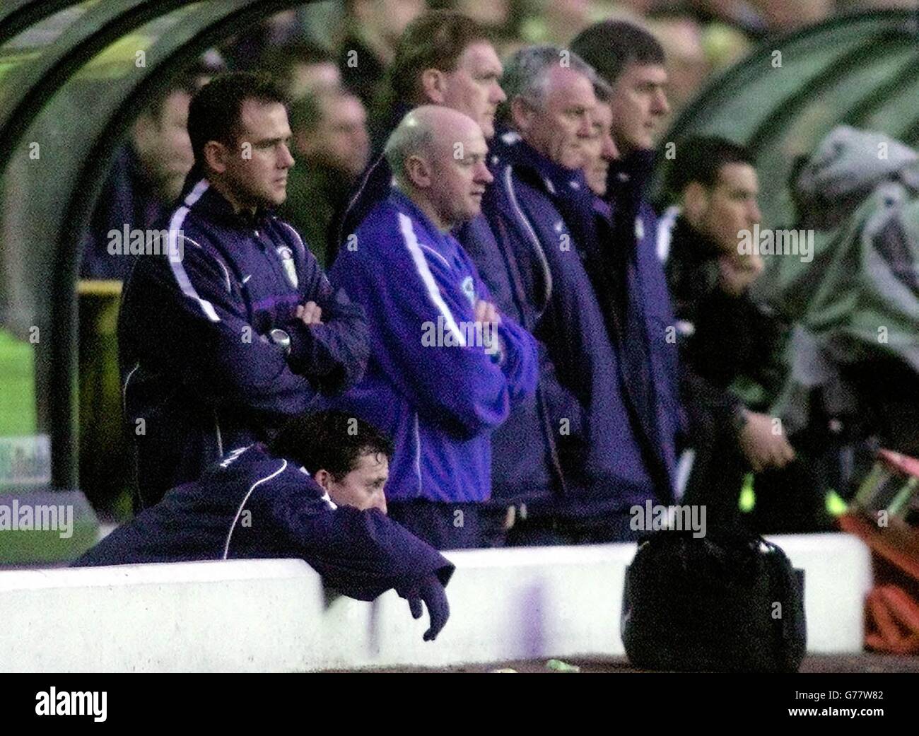 Leeds United's Robbie Fowler (bottom left) sits low in the dug out ...