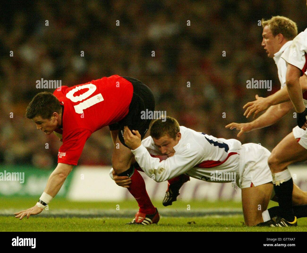 Welsh fly half Ceri Sweeney is caught by England's Jonny Wilkinson ...