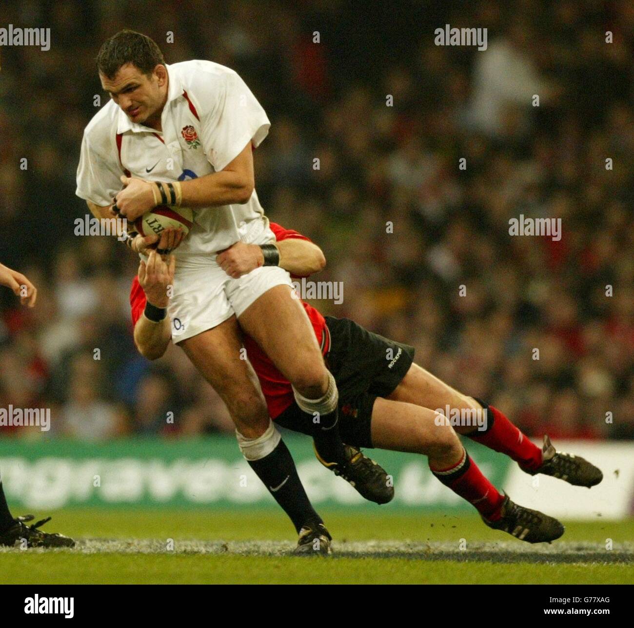 England captain Martin Johnson is held by the Welsh forwards during ...