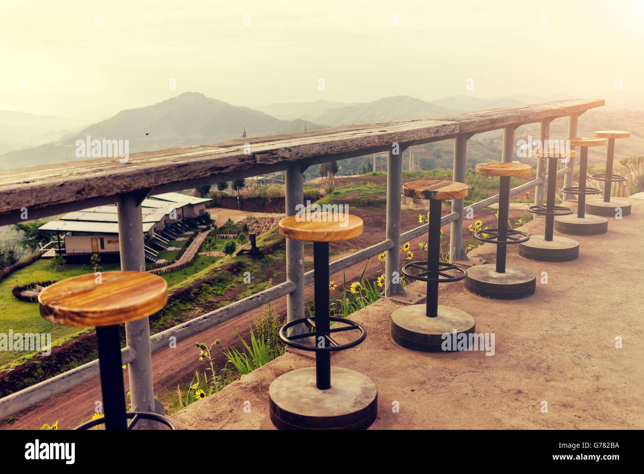 Lonely empty chairs on a deck at sunrise ready for treveler to sit and ...