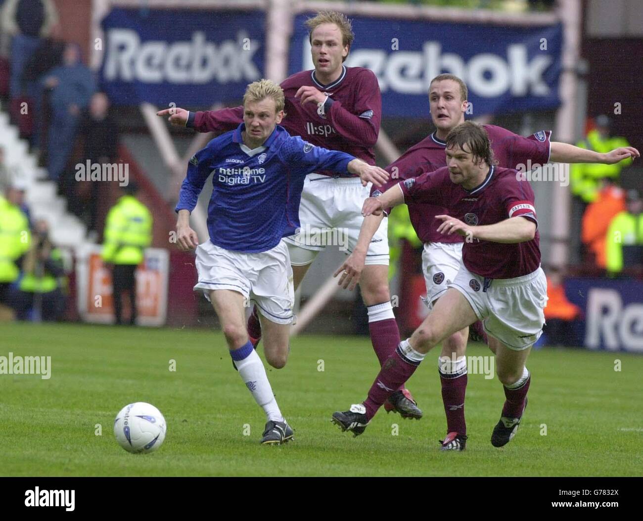 Ranger's Stephen Hughes (R) is tracked by Hearts players Steven Boyack ...