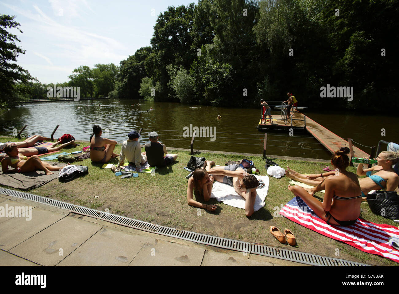 People sunbathing at the mixed bathing ponds in Hampstead Heath, London, during a spell of hot ...
