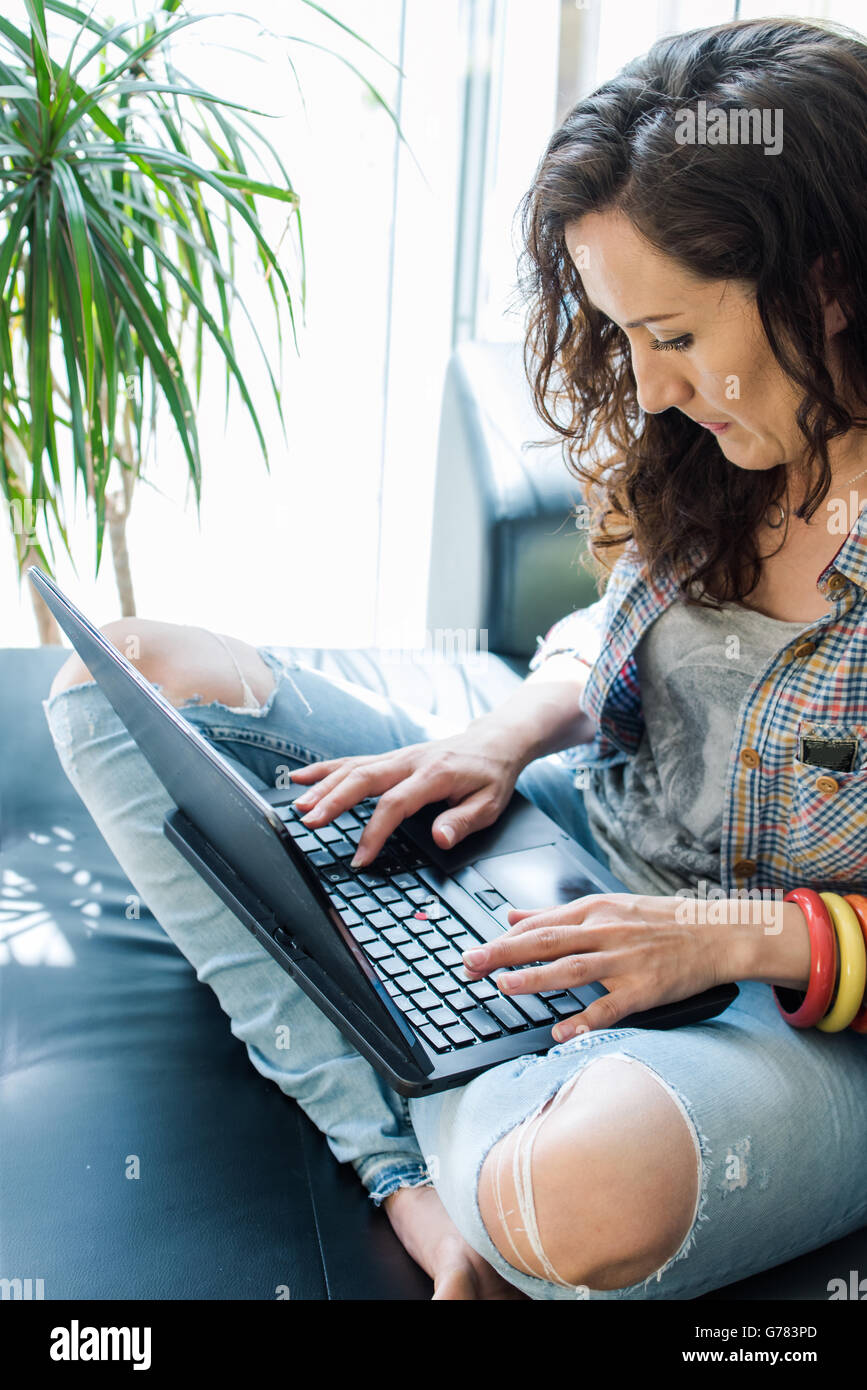 young lady working on laptop device in room, bright sun flare Stock ...