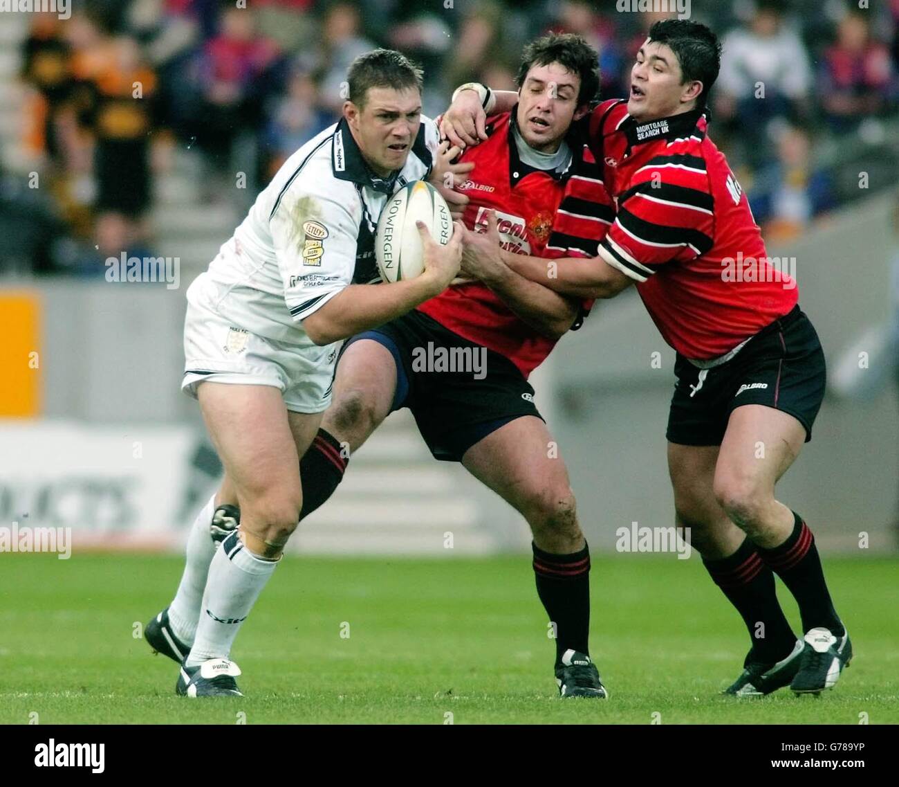Hull FC's Scott Logan pushes away Halifax's Heath Cruckshank (C) and Shane McMenemy during their ...