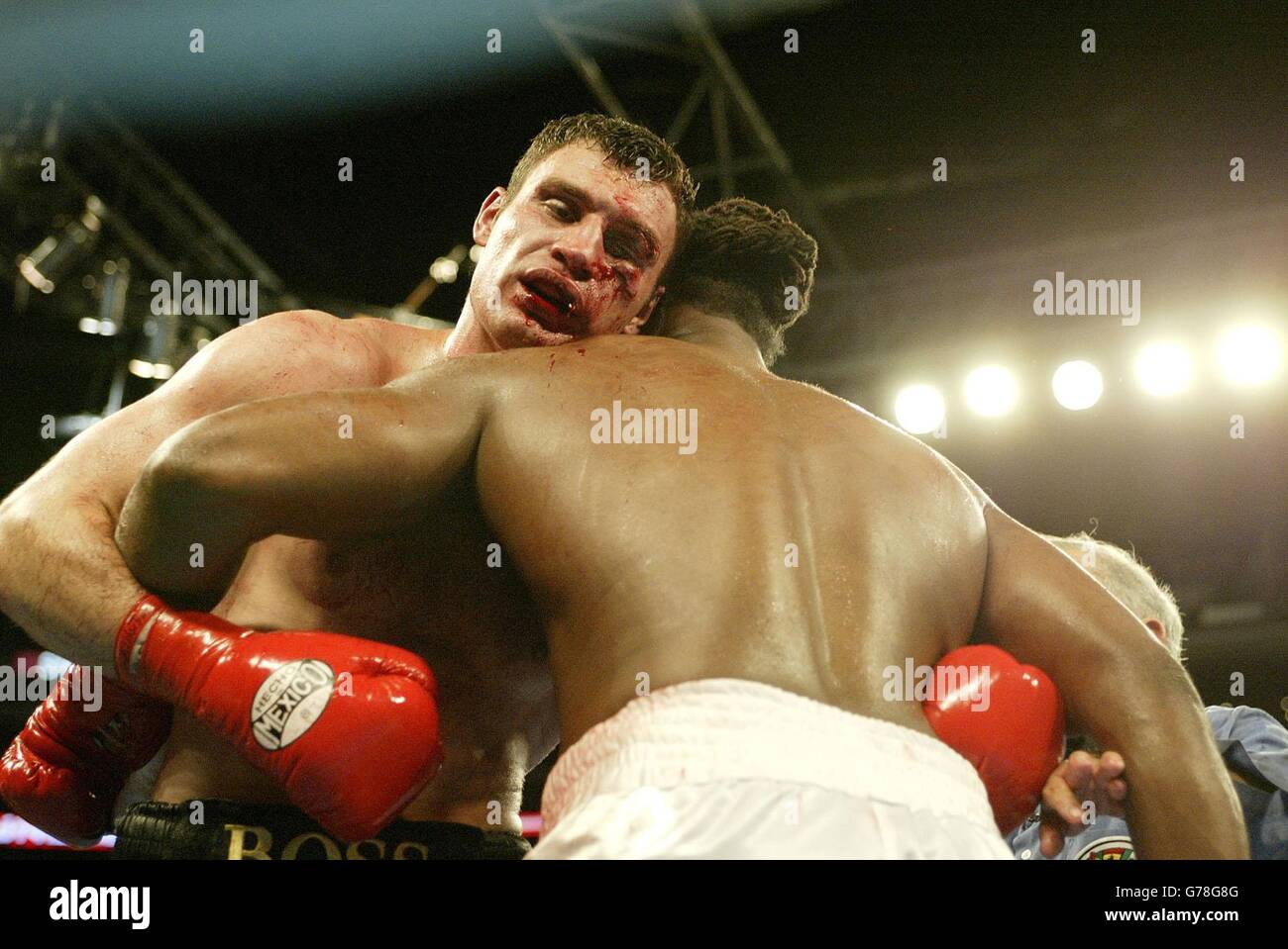 A very tired and with a badly cut left eye Vitali Klitschko (left) rest ...