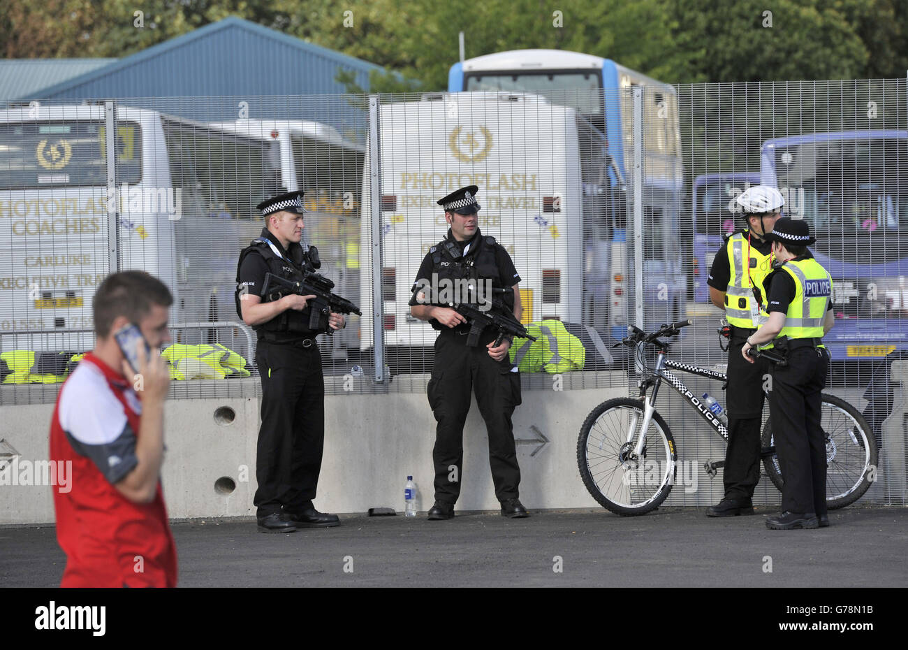 Armed Police Officers patrol a gate at the Athletes Village as security ...