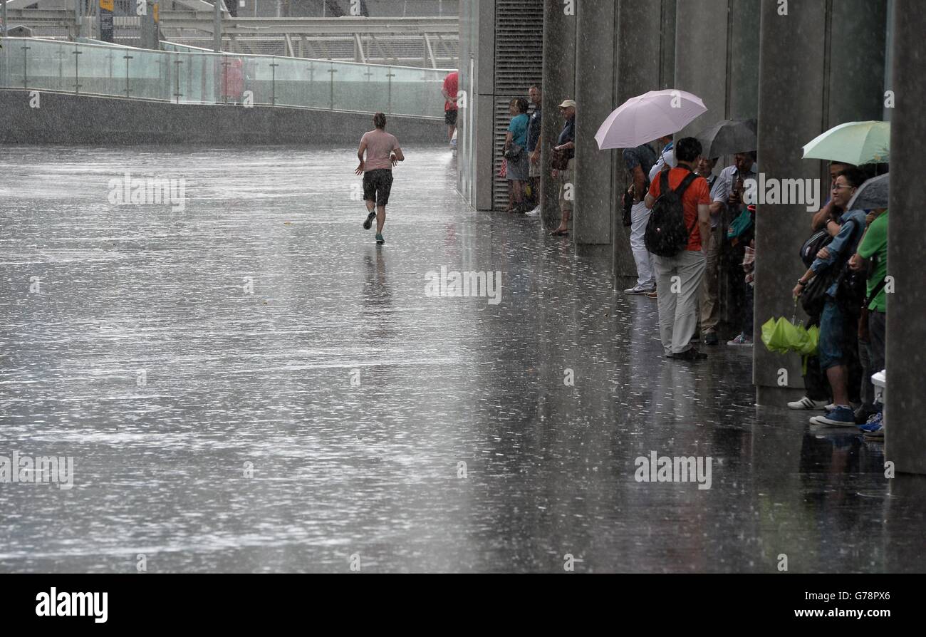 Tourists shelter as heavy rain falls near London Bridge, London Stock ...