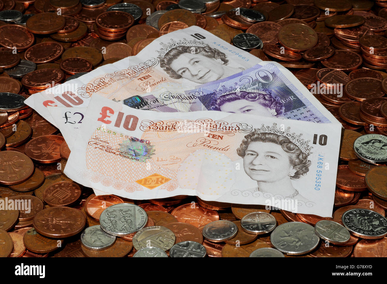 Ten and twenty pound notes on a pile of coins Stock Photo - Alamy