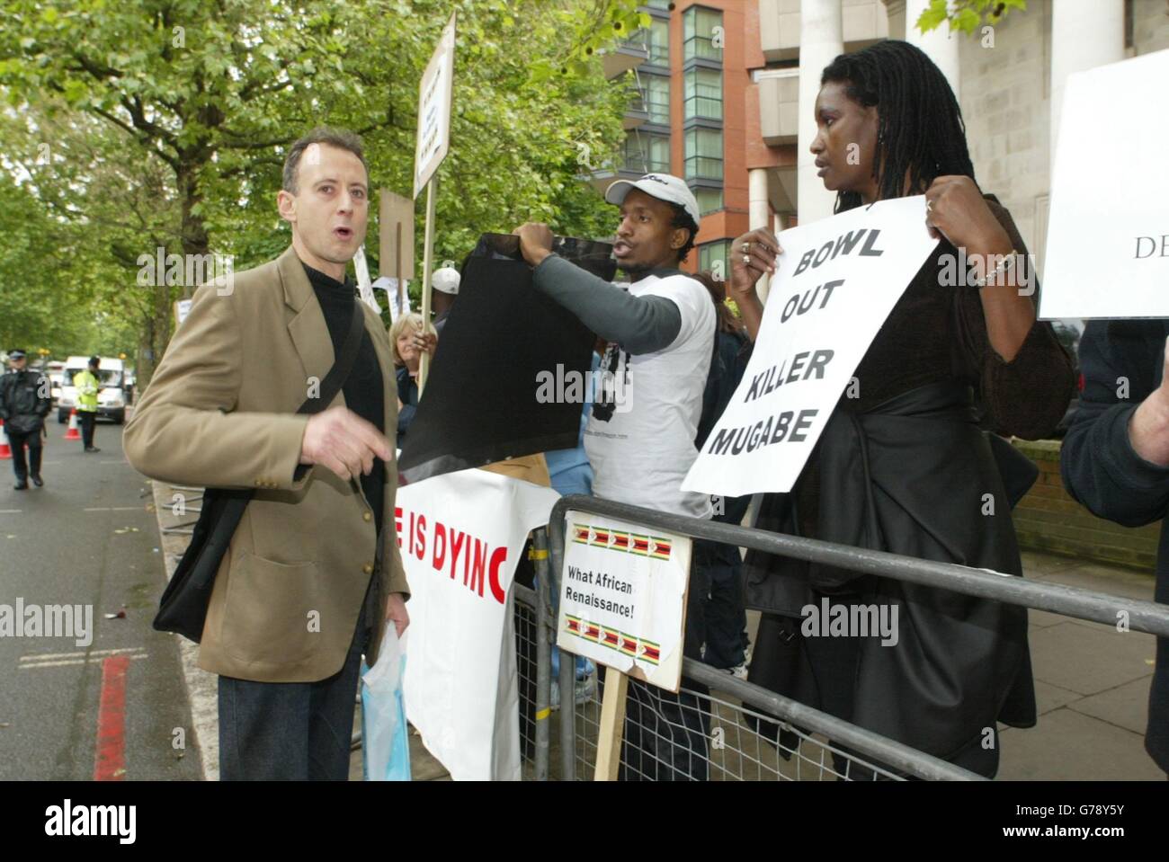 Human rights campaigner Peter Tatchell (left) talks to anti Mugabe ...