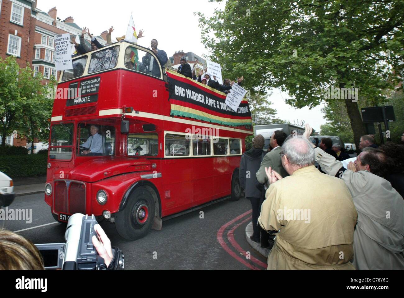 Anti Mugabe protesters make their point from an open top bus before the ...