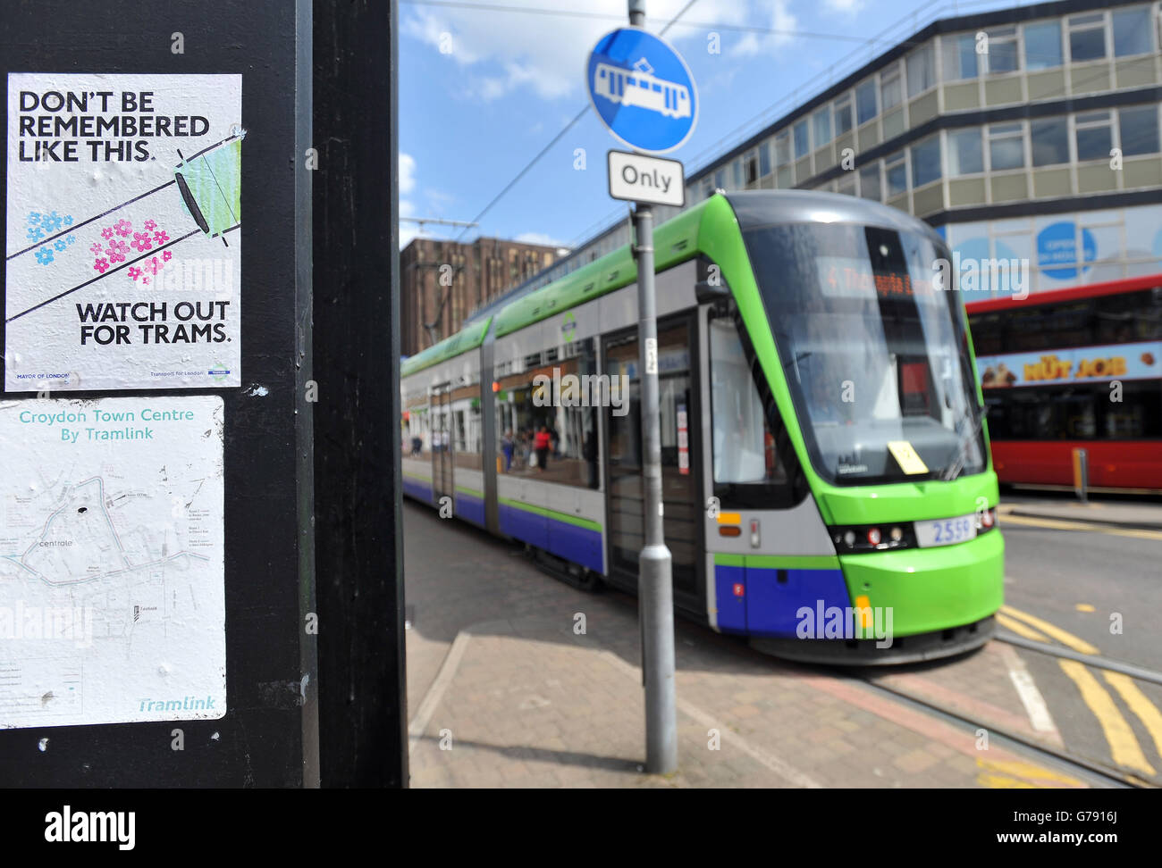 A Tramlink tram passes a warning sign on a post as it travels along ...