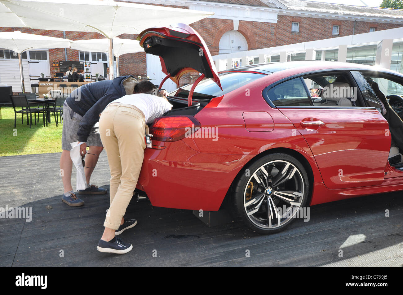 Car sales stand at Goodwood Festival of Speed. Inspecting boot of car ...
