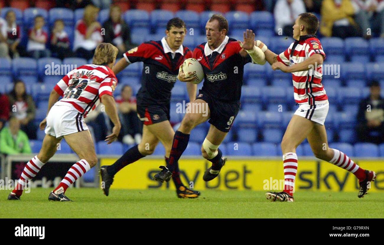 St Helens' Nick Fozzard tries to run through the Wigan defenders during ...