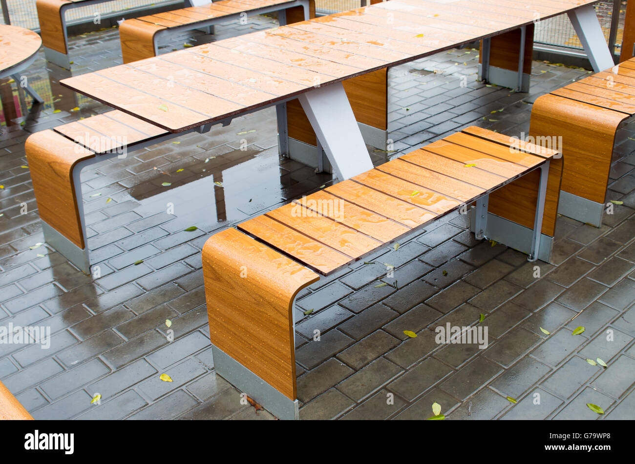 Selective focus of empty and wet outdoor cafe tables on the street ...
