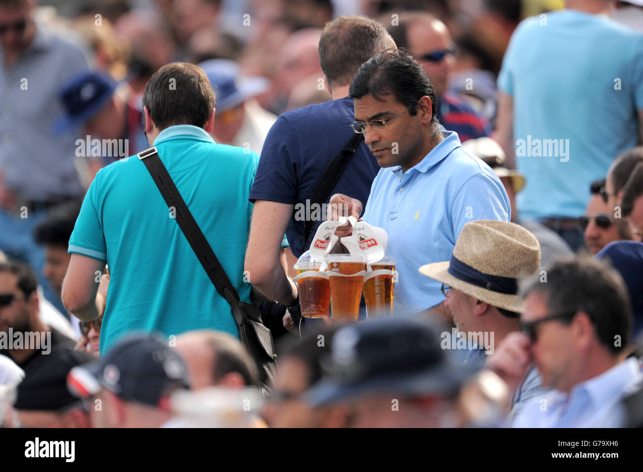 General view as members of the crowd grab drinks during a break in play ...