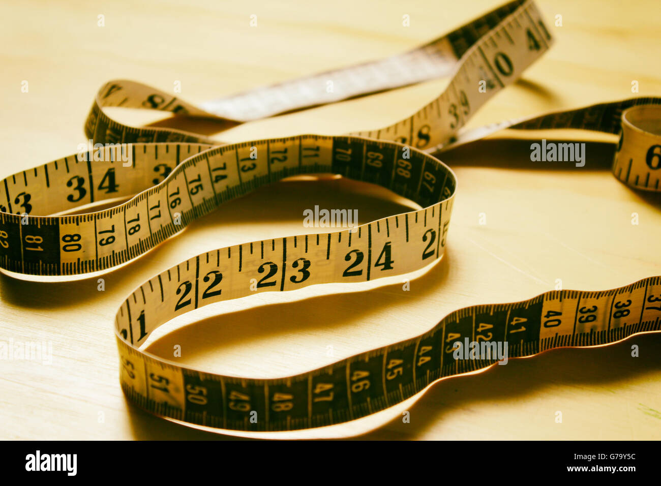 Photograph of a retro thin measuring tape on a wood table Stock Photo ...