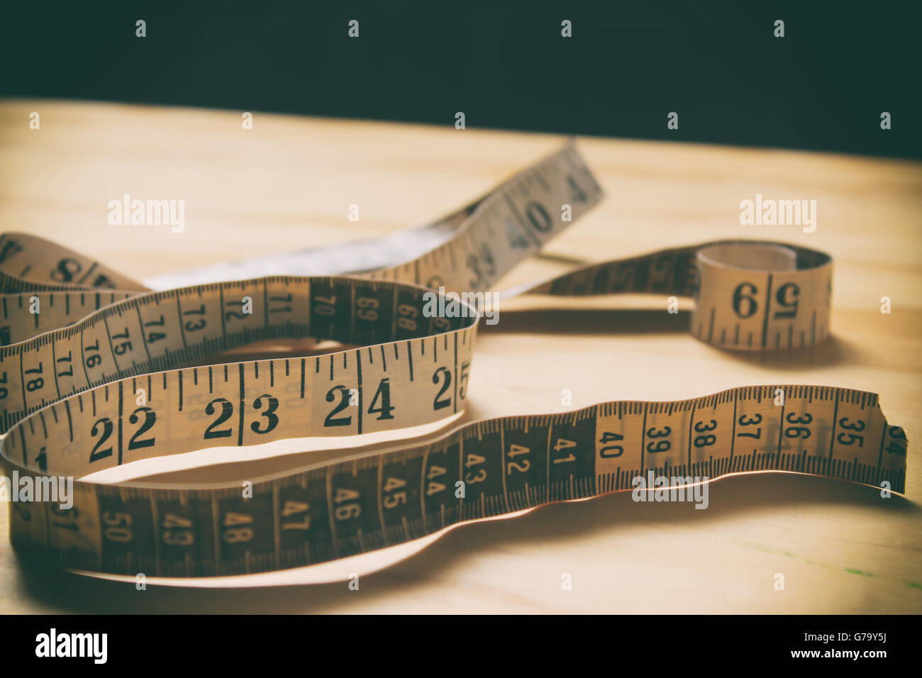Photograph of a retro thin measuring tape on a wood table Stock Photo ...