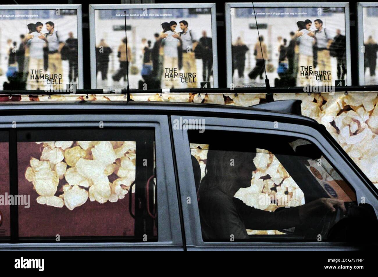 A taxi passes posters for the film 'The Hamburg Cell' which had its ...