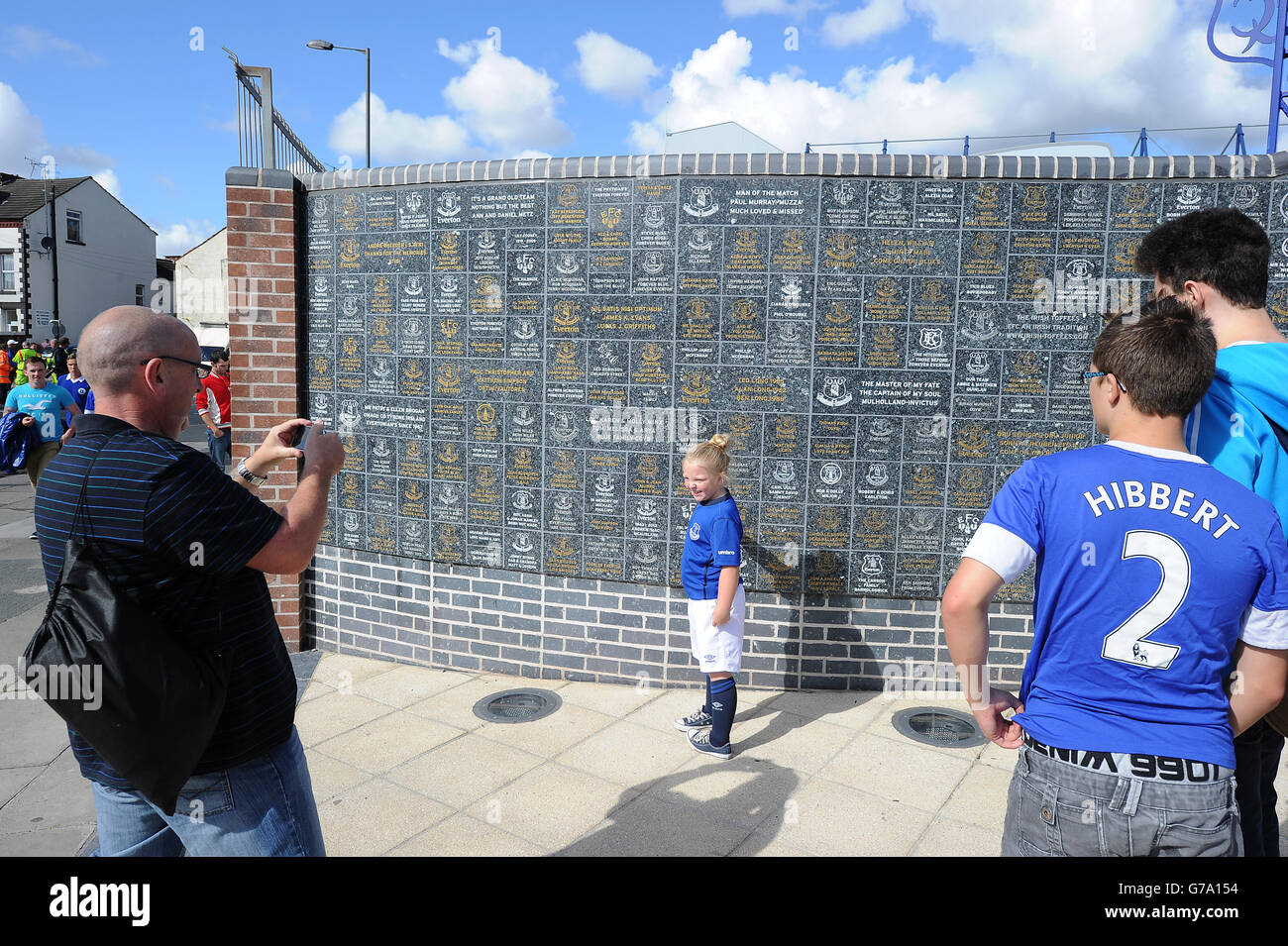 Everton fans pose for pictures in front of the wall of fame at Goodison ...